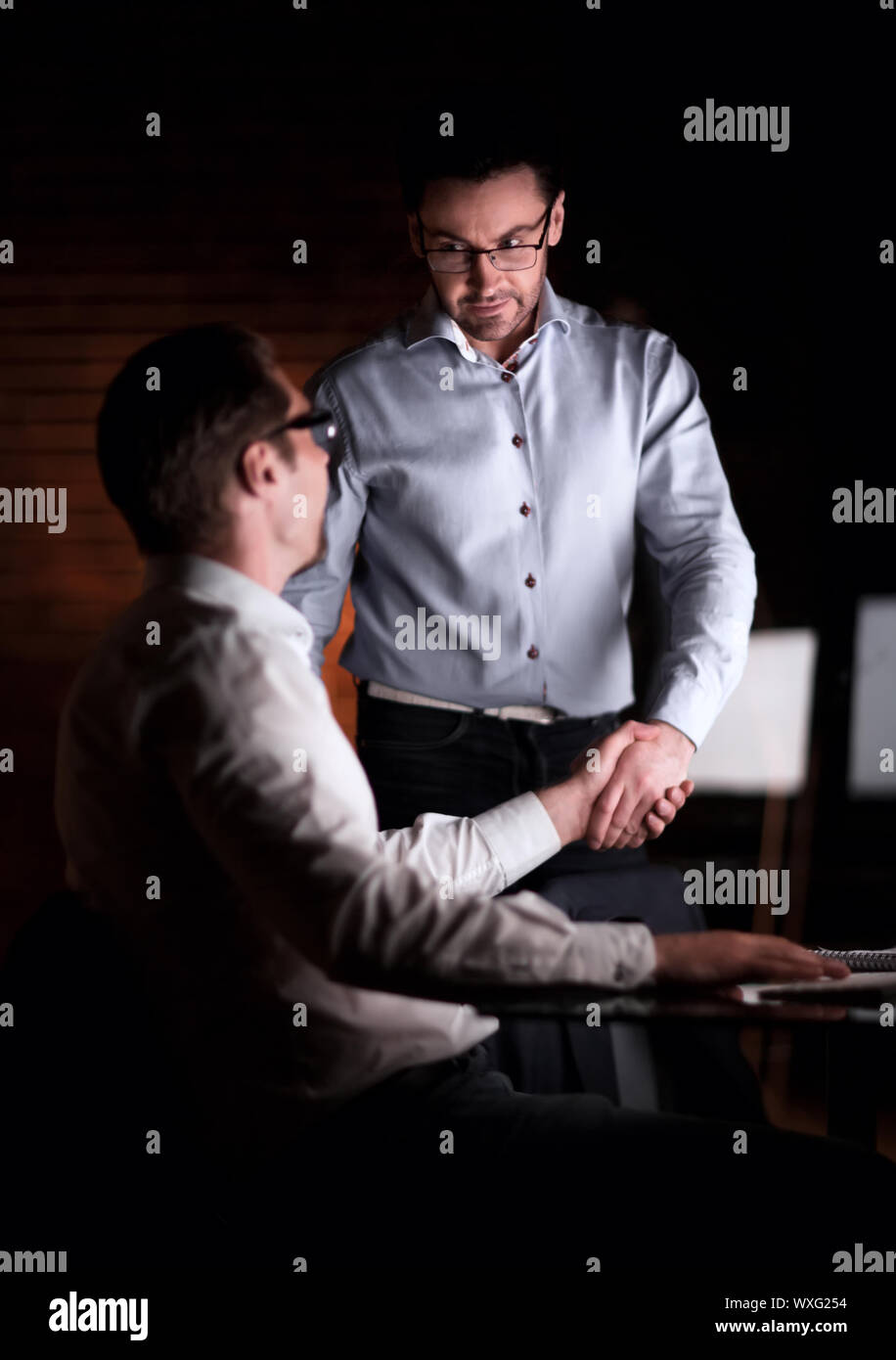 employees shaking hands near the desktop Stock Photo - Alamy