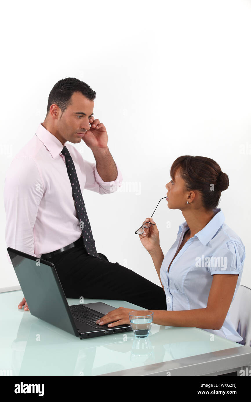 Flirtatious business duo Stock Photo - Alamy