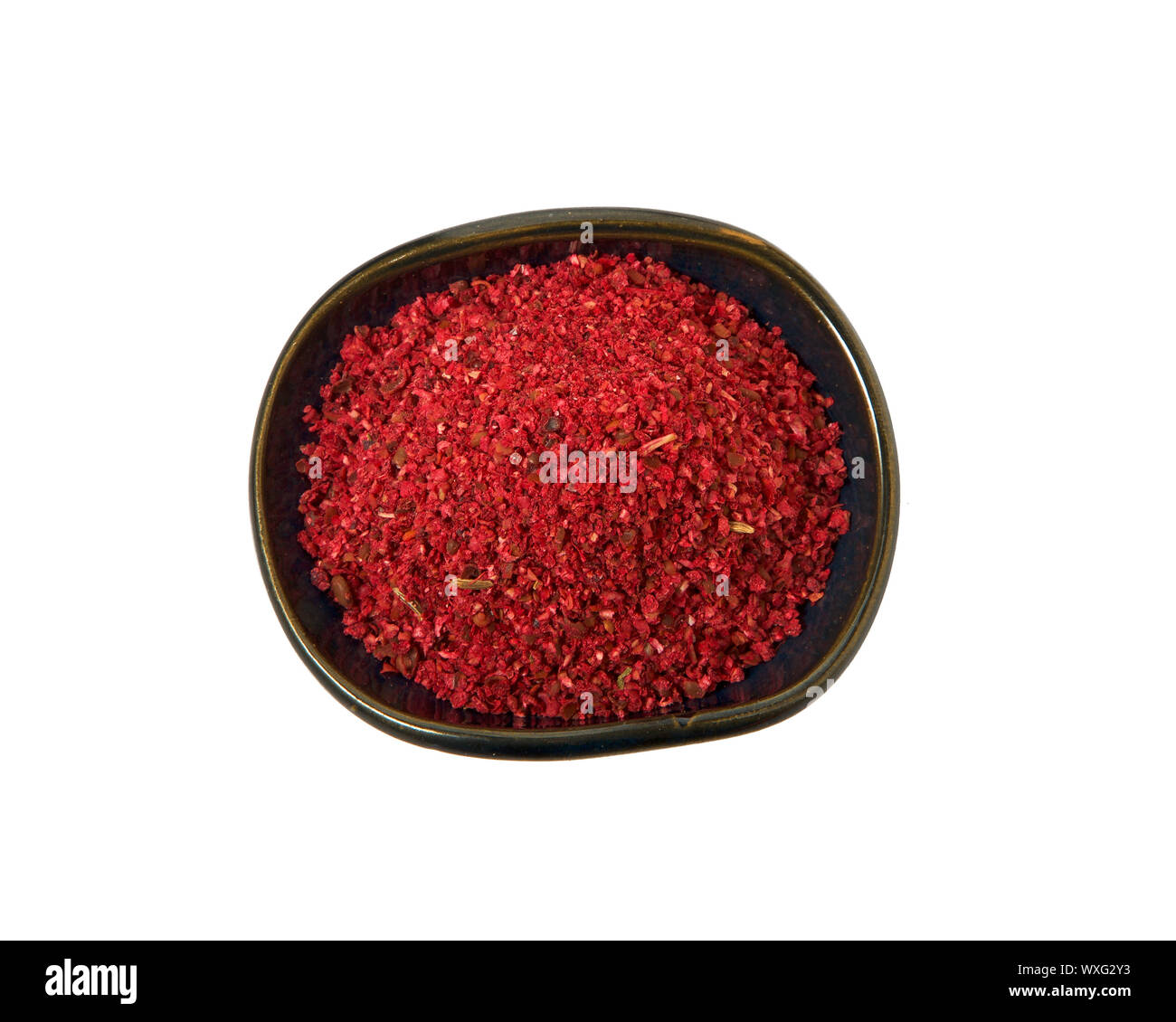 Ground red pepper in a bowl isolated on a white background. View from ...