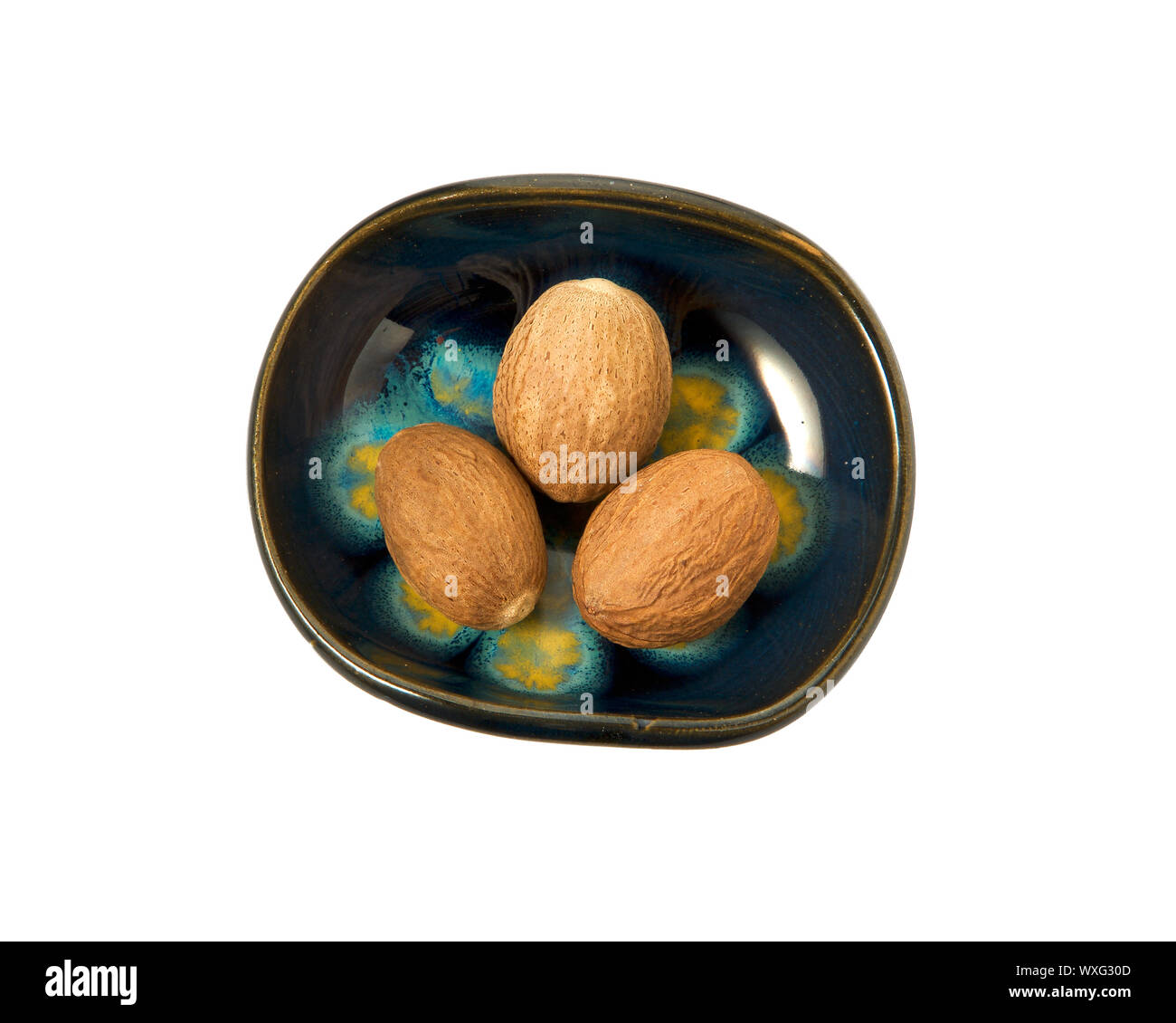Nutmeg in a bowl isolated on a white background. Seasoning on isolate ...