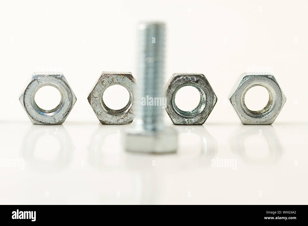 four screws standing behind one bolt on white background Stock Photo ...