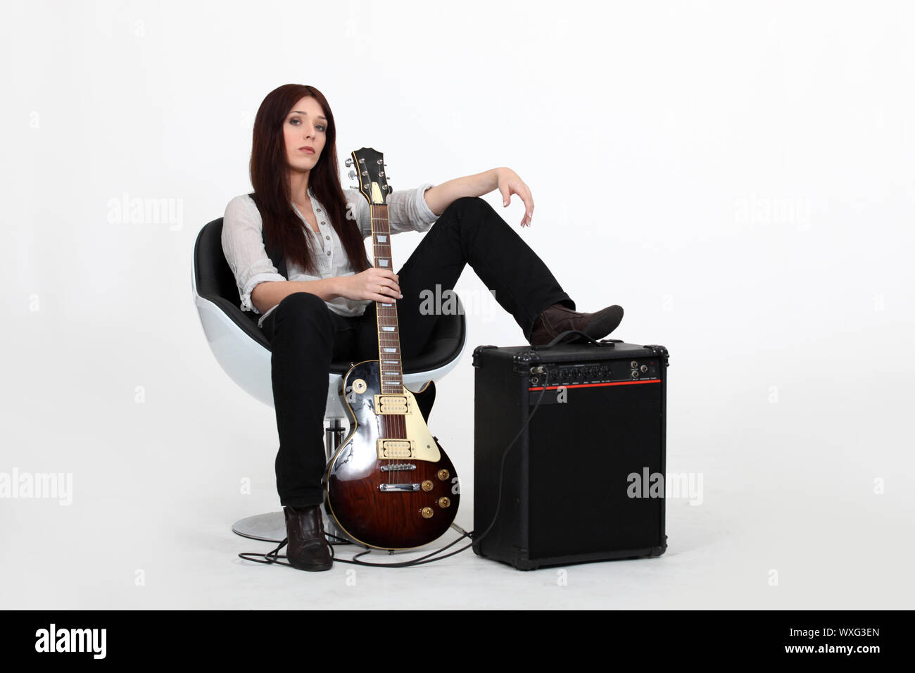 Woman with her foot propped on an amplifier and holding a guitar Stock ...