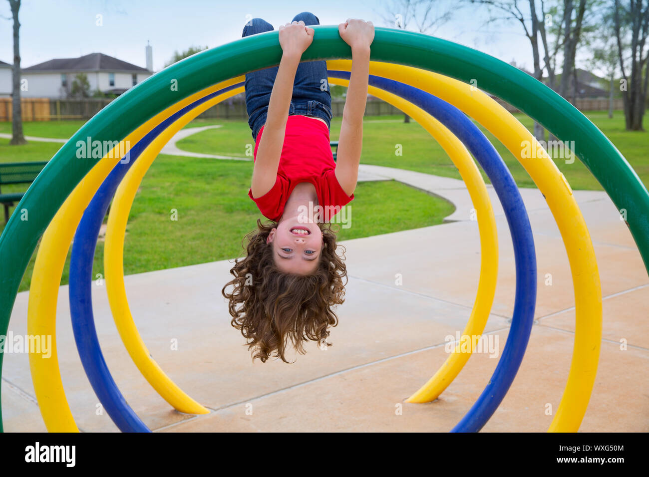 children kid girl upside down on a park playground ring game Stock ...