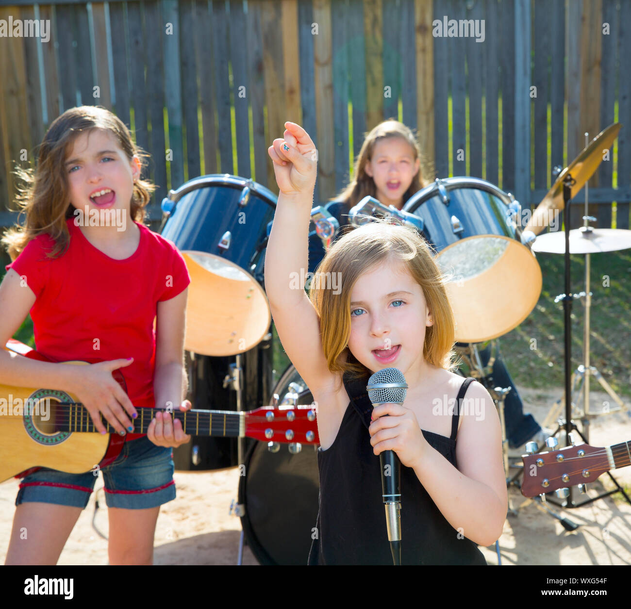 Blond kid singer girl singing playing live band in backyard concert ...