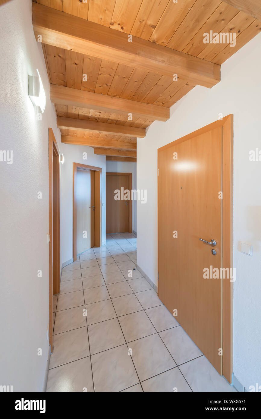 Corridor in an apartment with doors and white tiles Stock Photo - Alamy