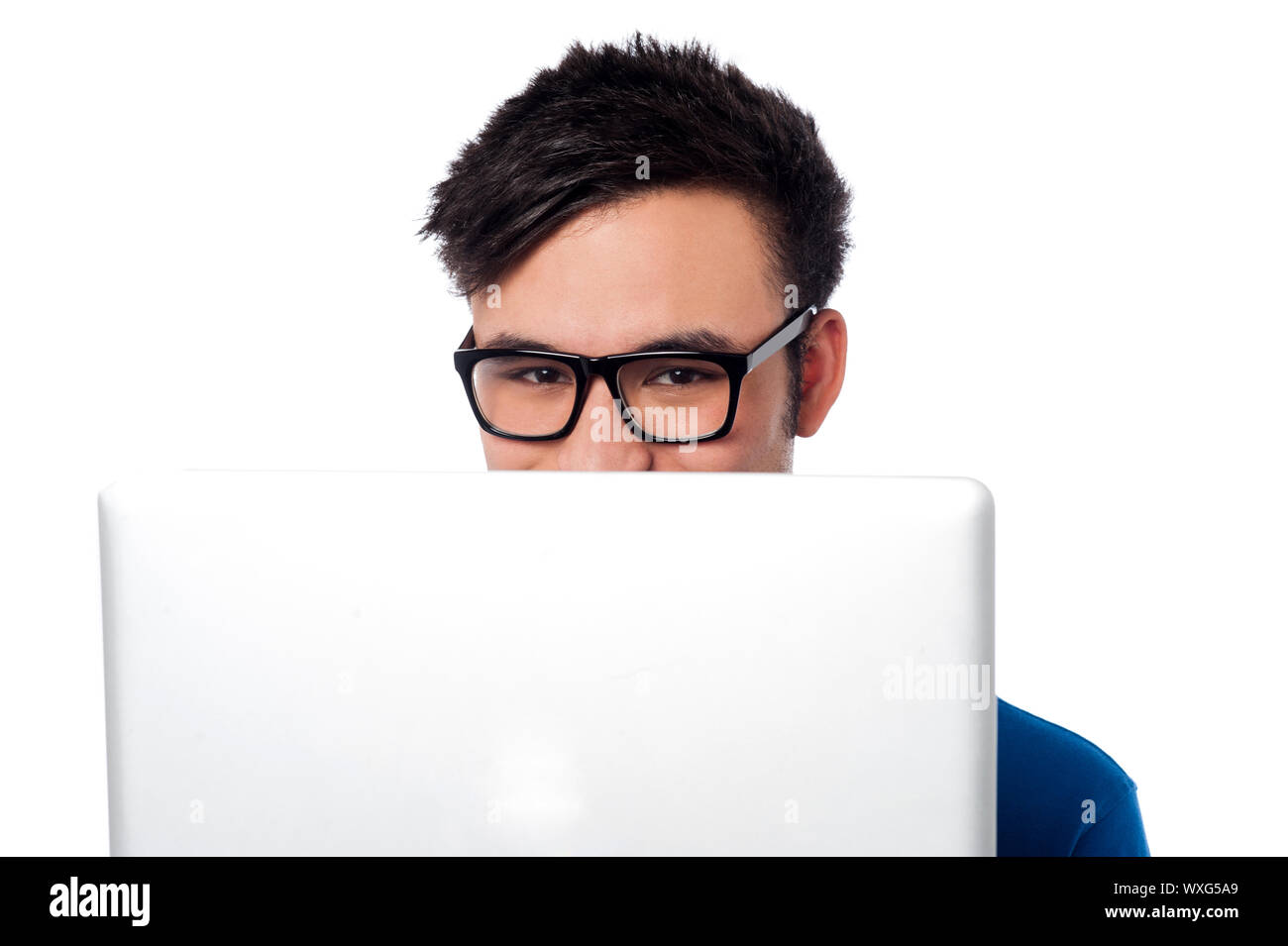 Boy in spectacles hiding his face behind laptop Stock Photo - Alamy