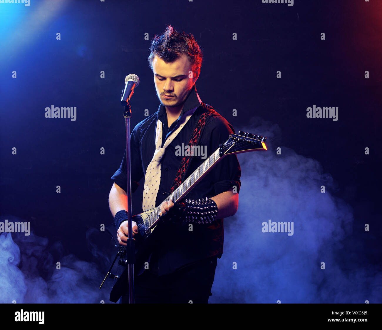 Young man playing guitar on stage at a rock concert Stock Photo - Alamy