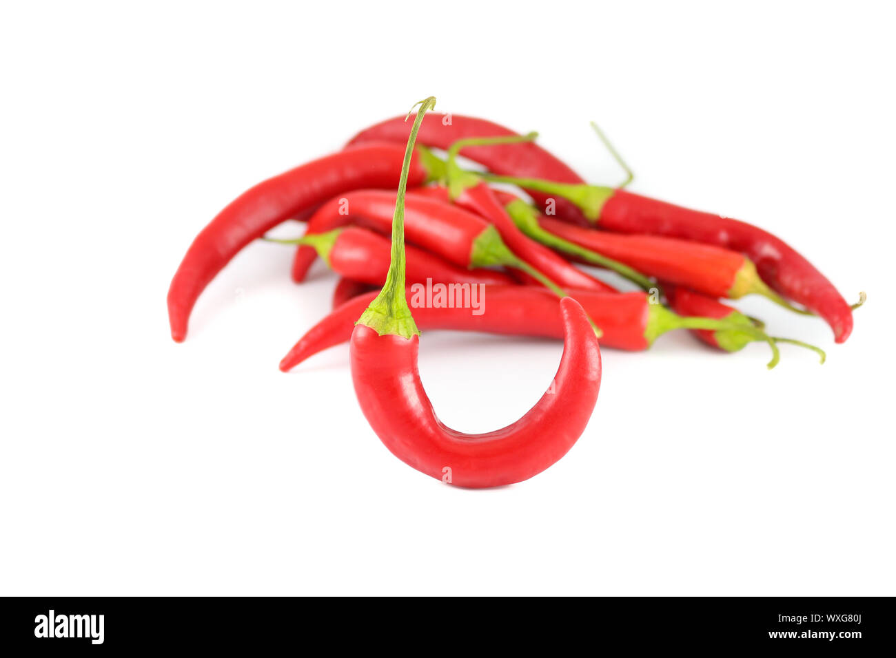 A single red hot chili pepper at the front with many others at the ...