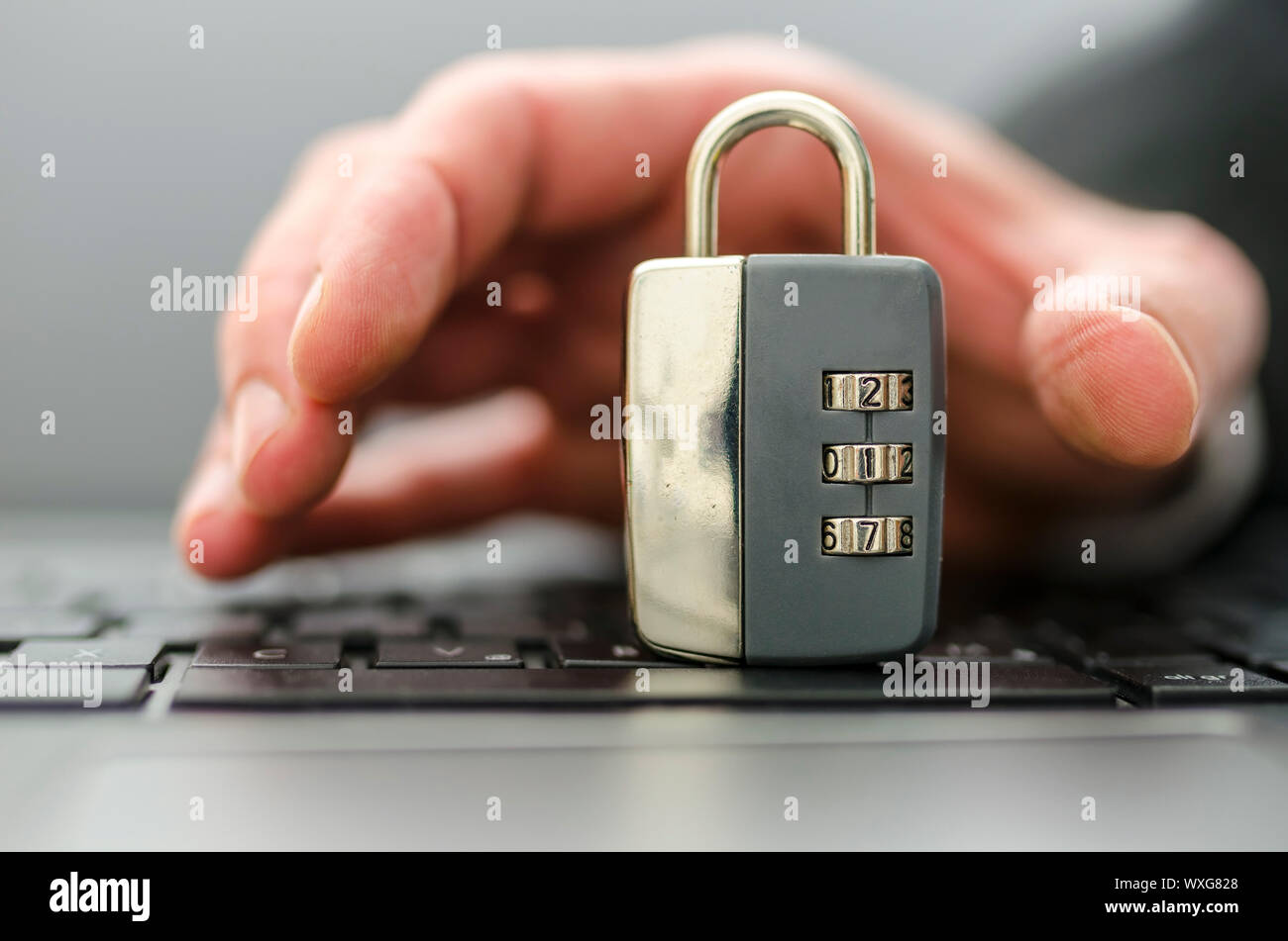 Male hand stealing padlock off computer keyboard Stock Photo - Alamy