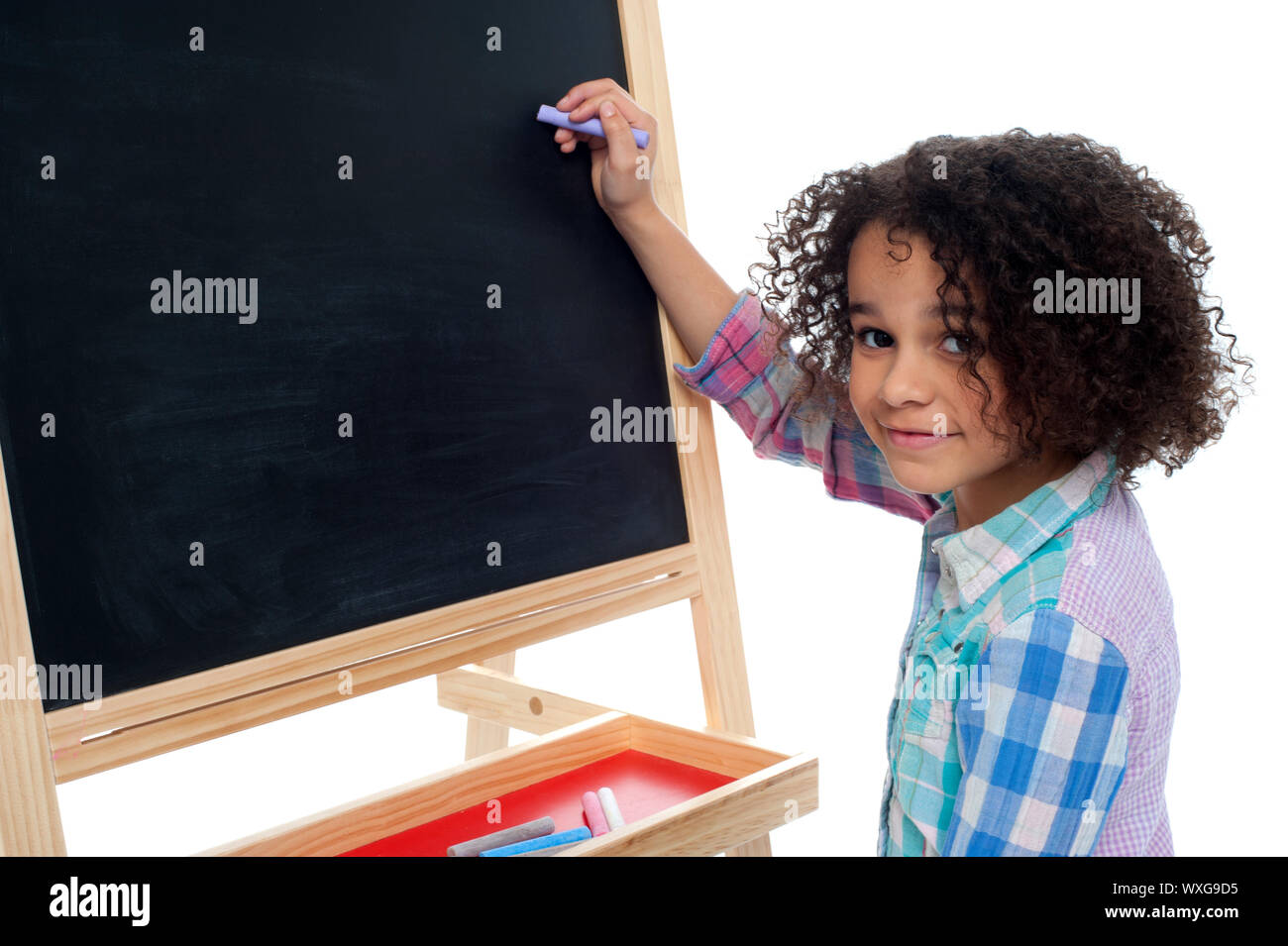 Happy schoolchild writing on blackboard Stock Photo - Alamy