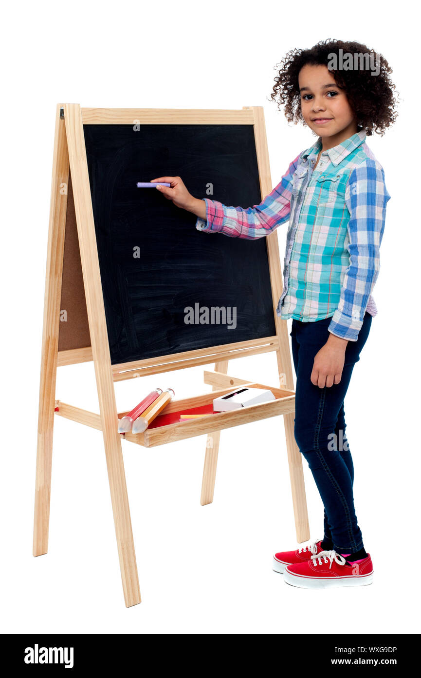 Beautiful little girl writing on classroom board Stock Photo - Alamy