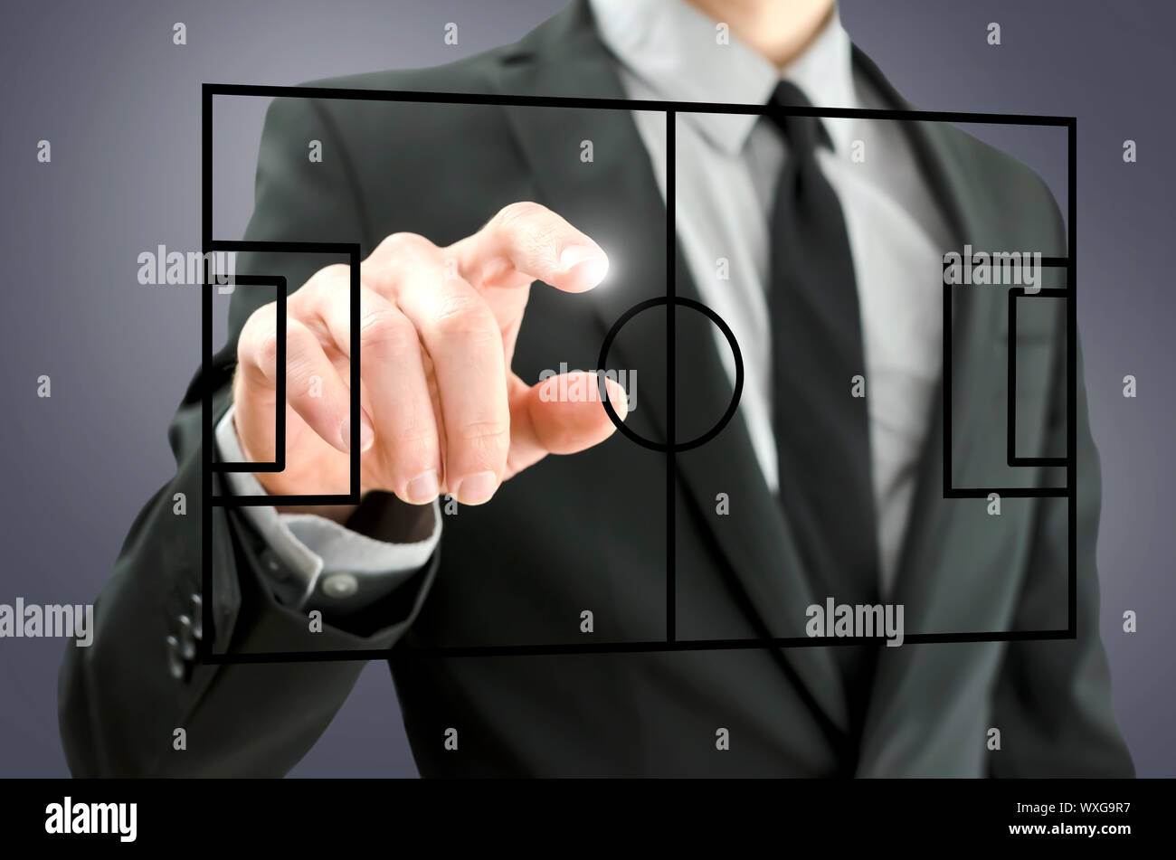 Coach pointing at football field on virtual screen Stock Photo - Alamy