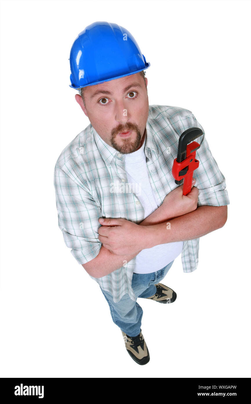 Grumpy plumber posing with wrench Stock Photo - Alamy
