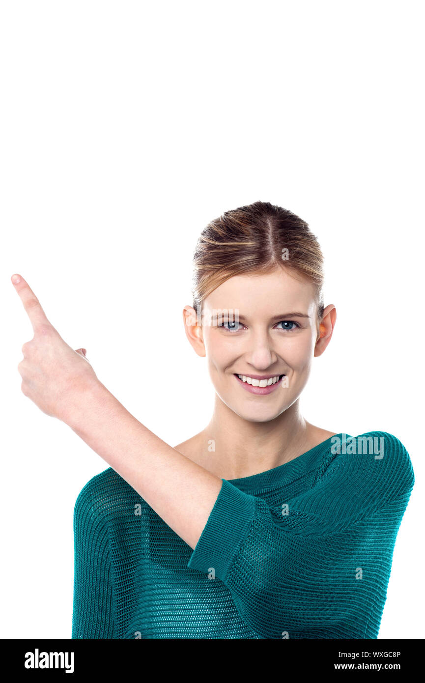 Young smiling female model pointing away Stock Photo - Alamy
