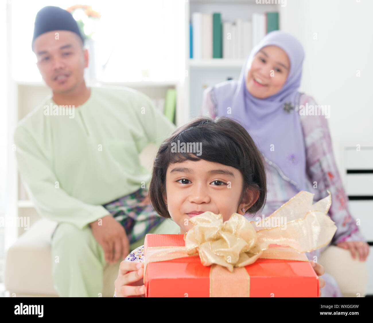 Southeast Asian girl with gift box. Muslim family living lifestyle ...