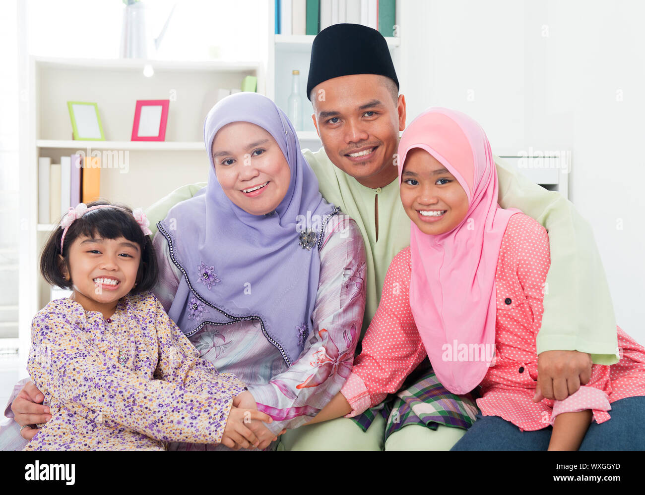 Happy Asian family at home. Muslim family having fun indoors. Southeast ...