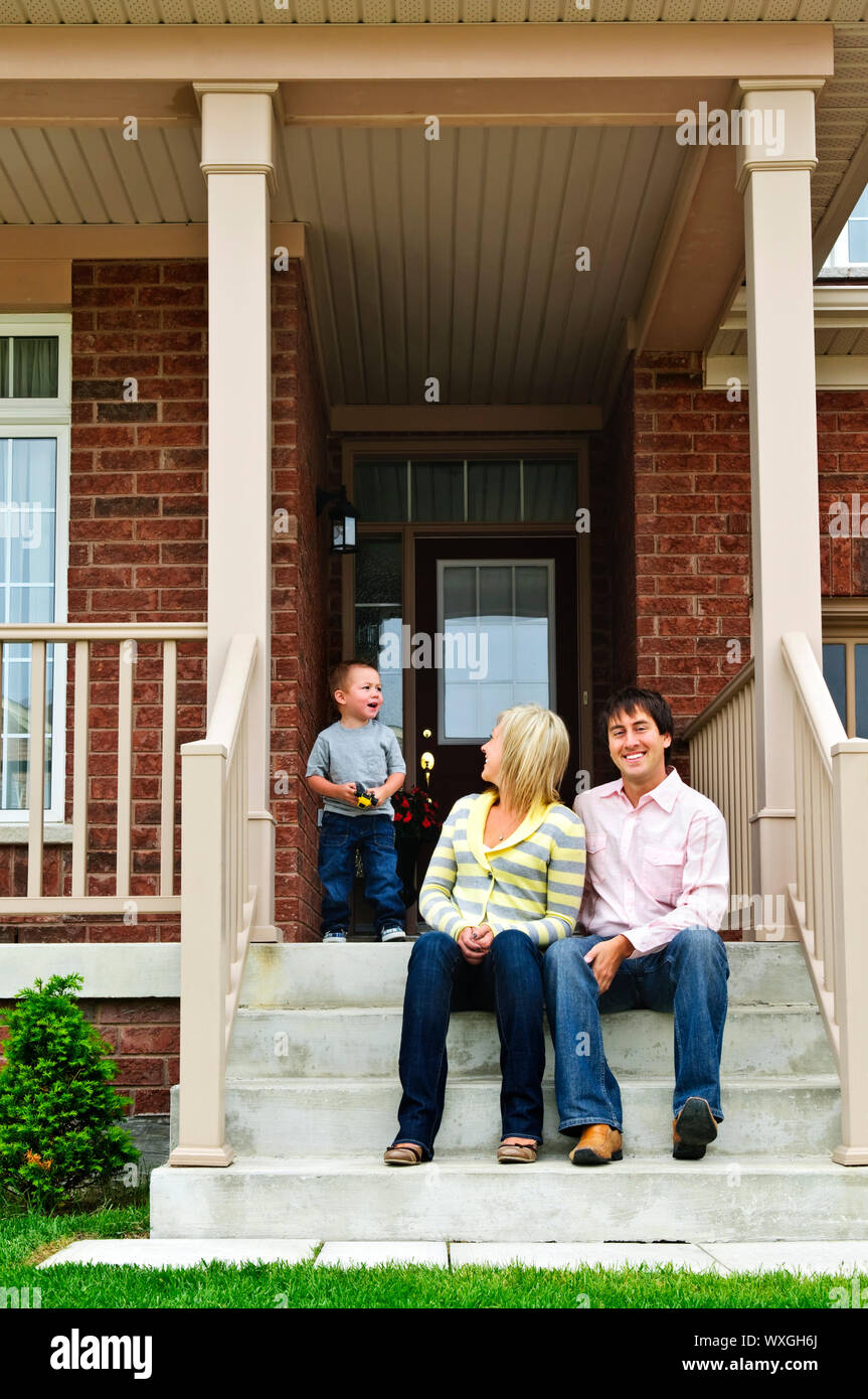 Young family sitting on front steps of house Stock Photo - Alamy