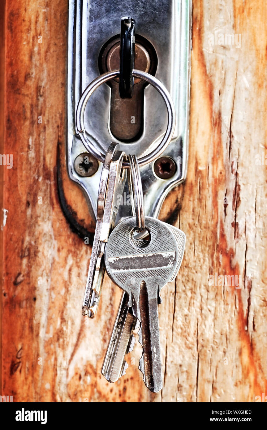 Set of keys in lock of old wooden door Stock Photo - Alamy
