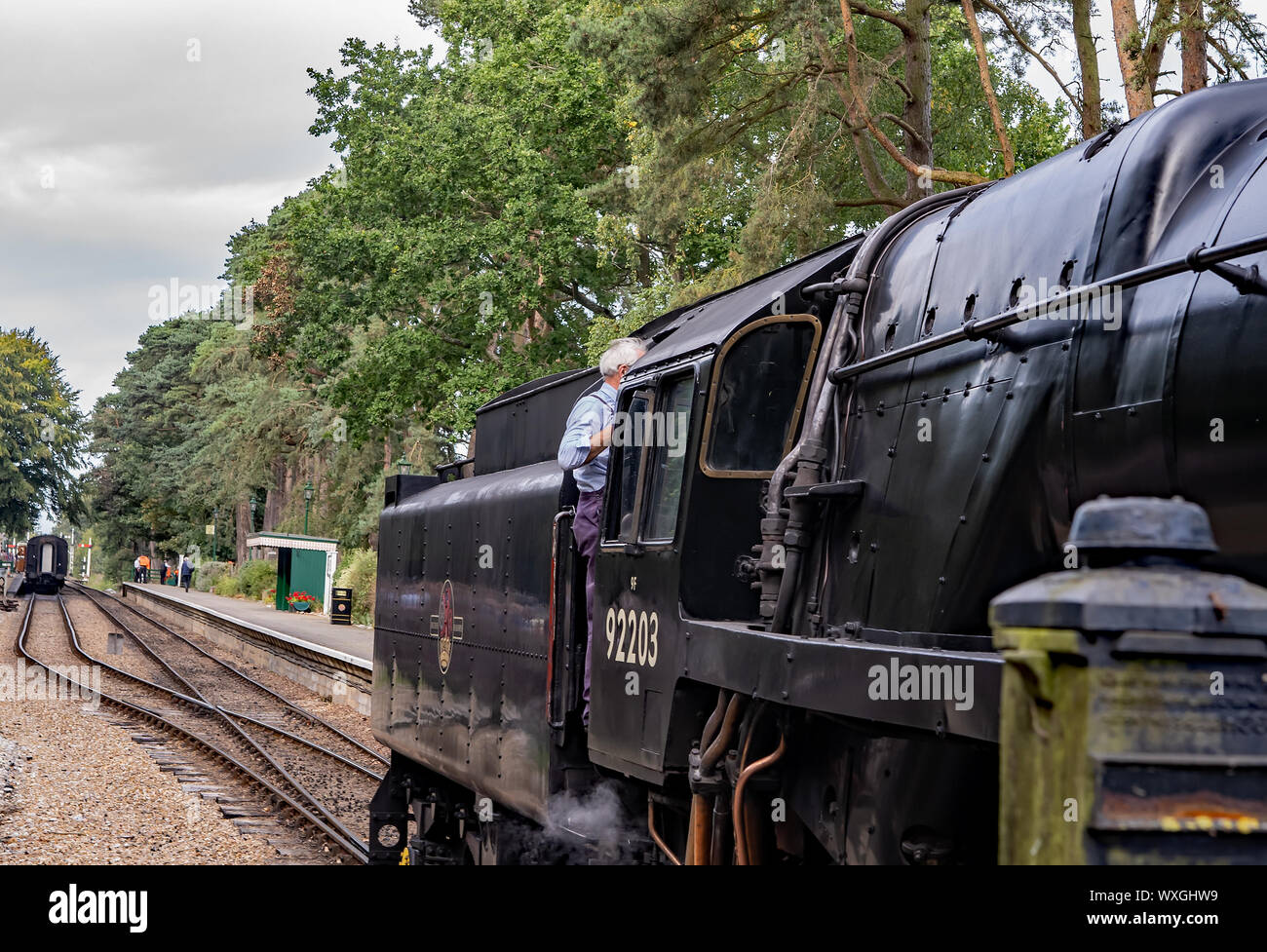Train driver parking up black steam train on the Poppy railway line in ...