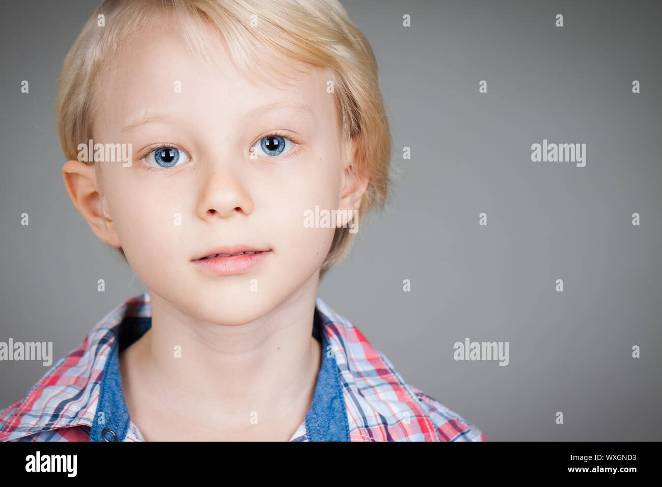 A close-up portrait of a serious young boy looking at camera Stock ...