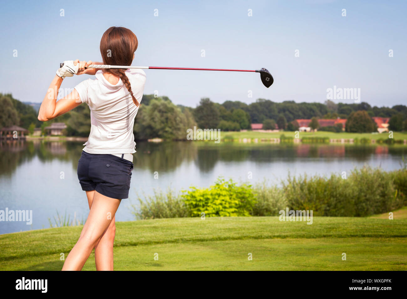 Golf player teeing off Stock Photo - Alamy