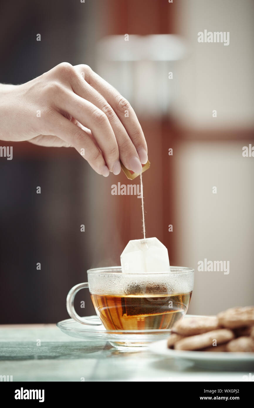 Human hands making tea Stock Photo - Alamy