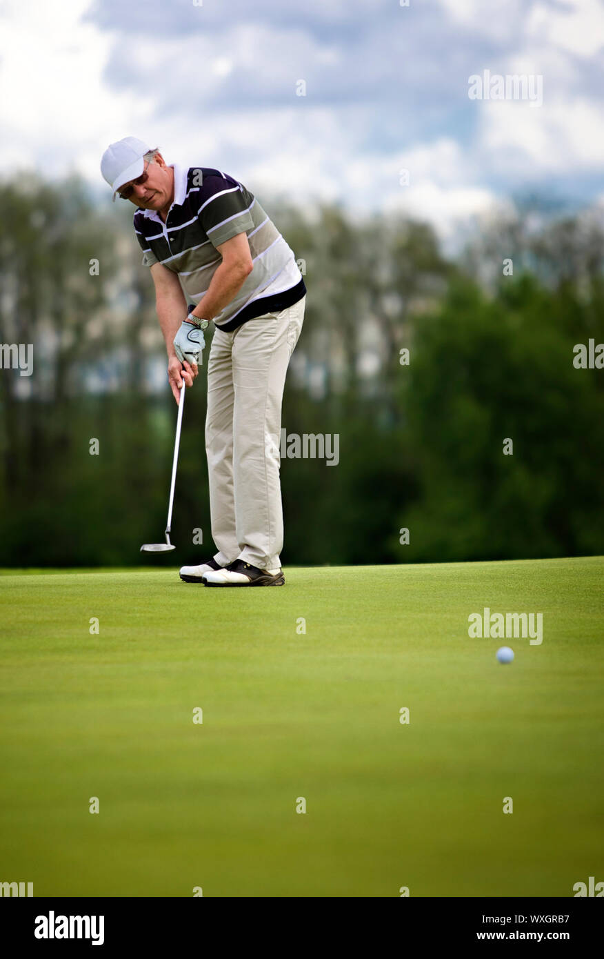 Senior golf player putting Stock Photo - Alamy