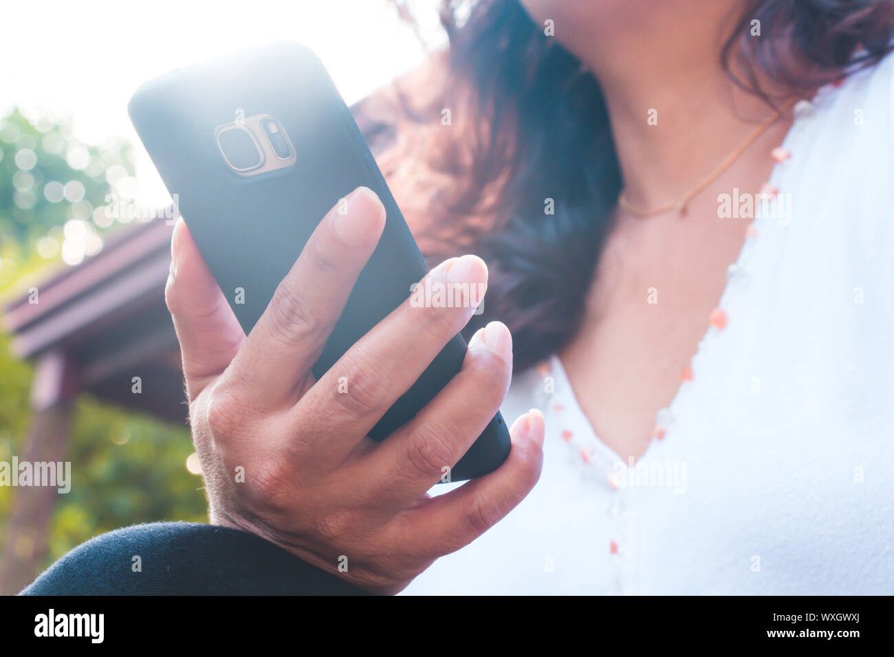 Back view close up of a woman hand using a smart phone Stock Photo - Alamy