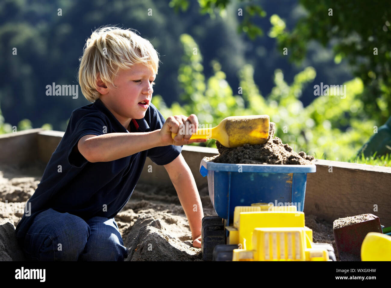 Boy playing in sandbox Stock Photo - Alamy
