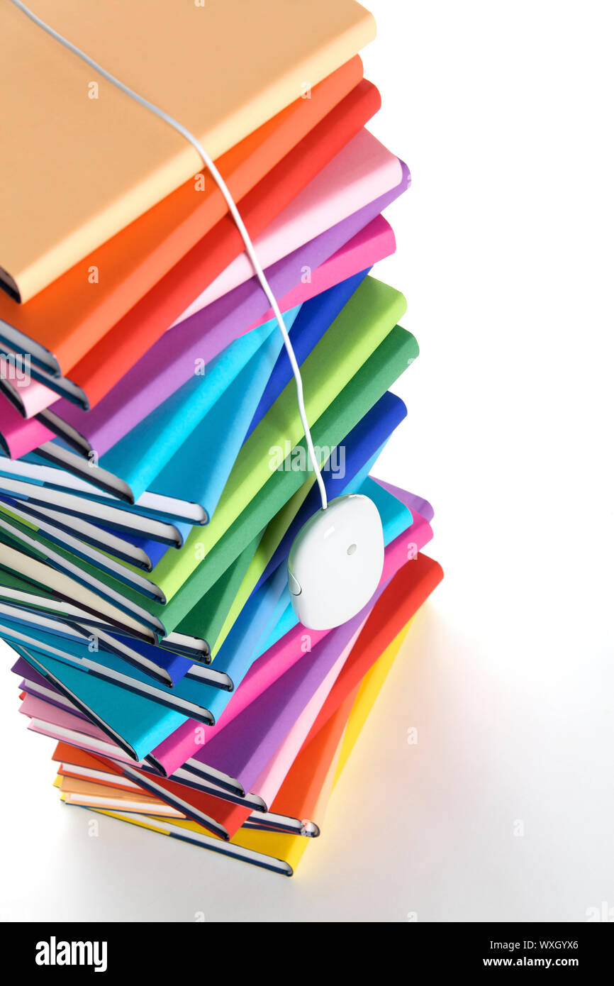 Mouse hanging from top of multi-colored book stack Stock Photo - Alamy