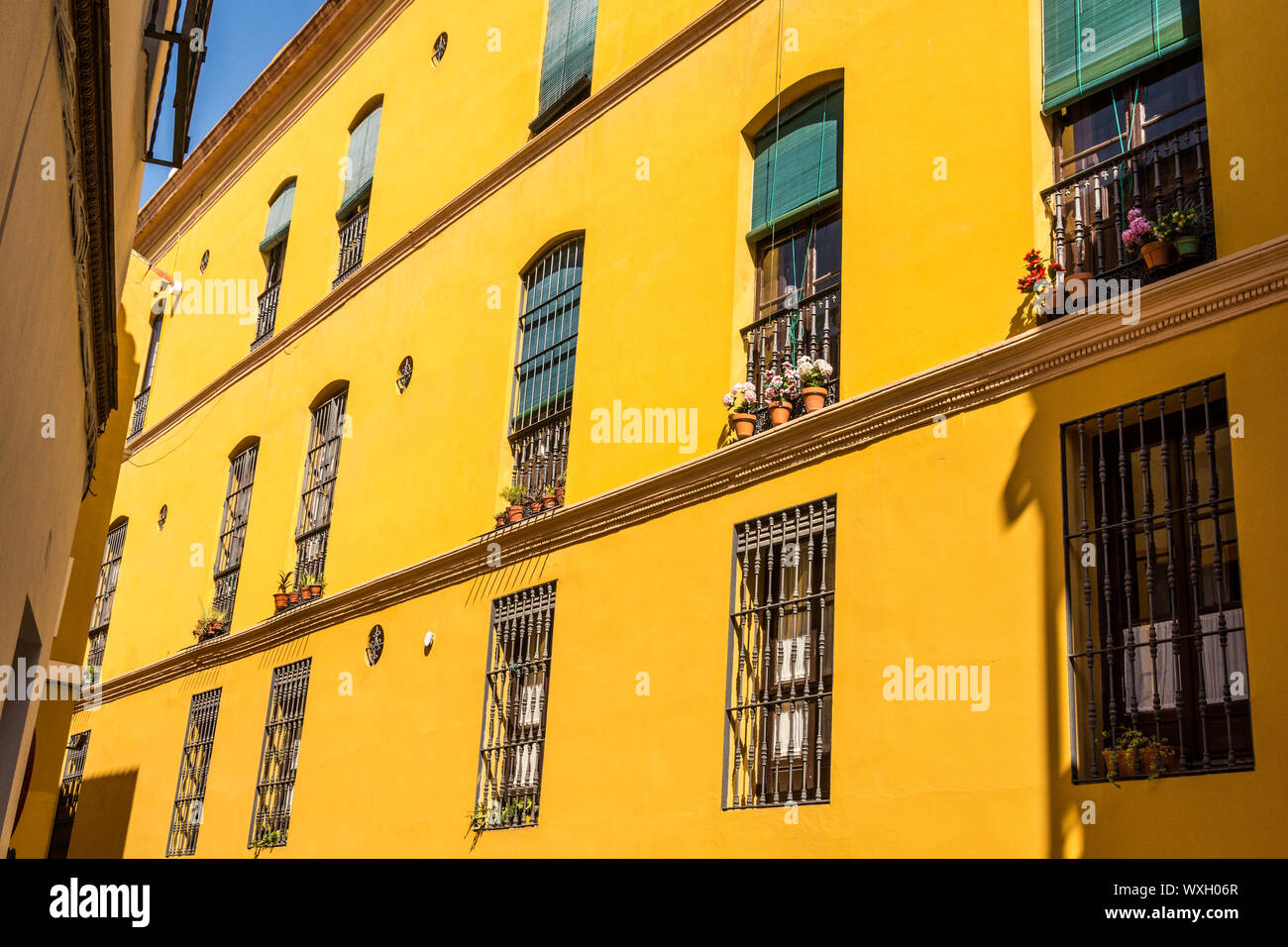 A building in Seville, Spain painted a gold and yellow color Stock ...