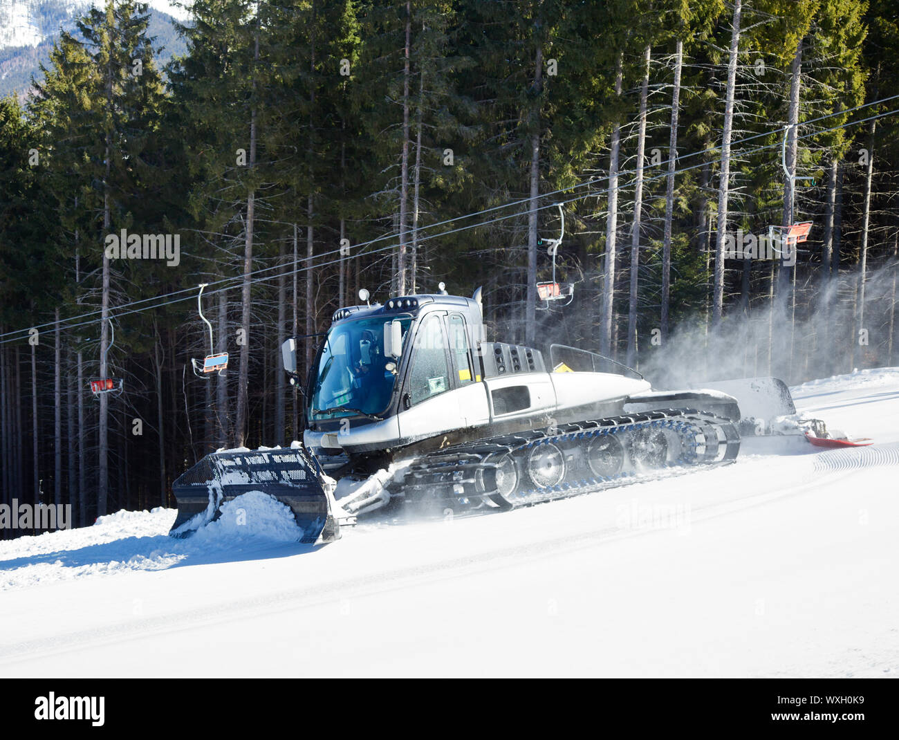 Moving piste basher on a ski slope Stock Photo - Alamy