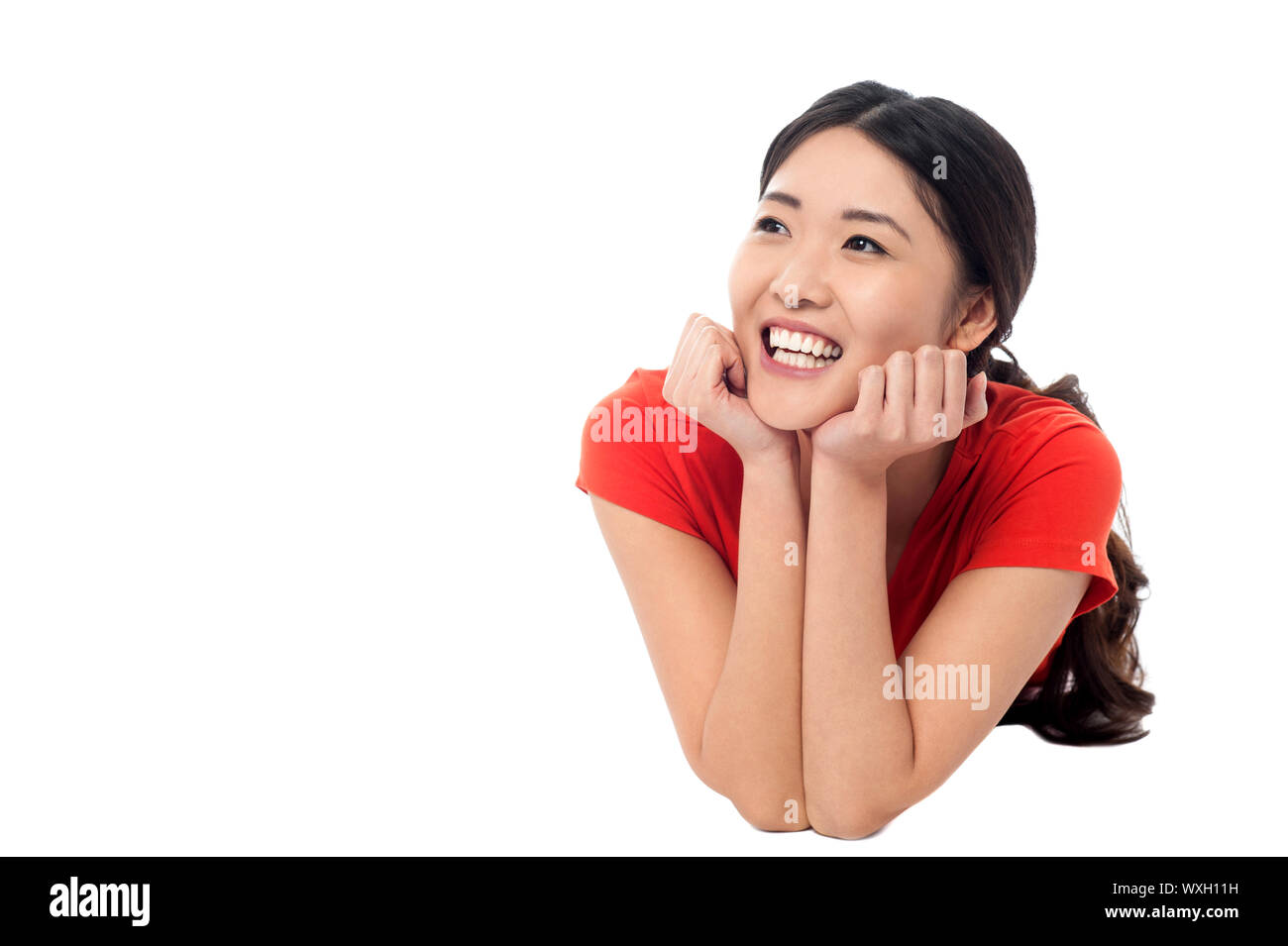 Girl in studio thinking of something and smiling Stock Photo - Alamy