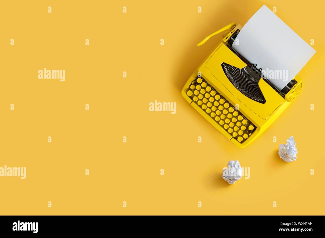 Orange retro typewriter on paper background with crumpled pieces of ...