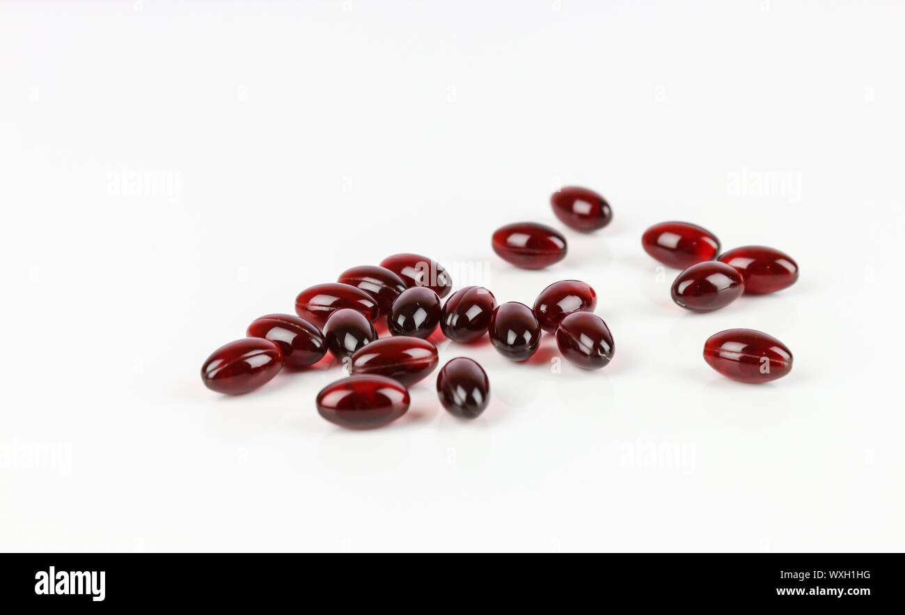 red gel capsules isolated on white background Stock Photo - Alamy