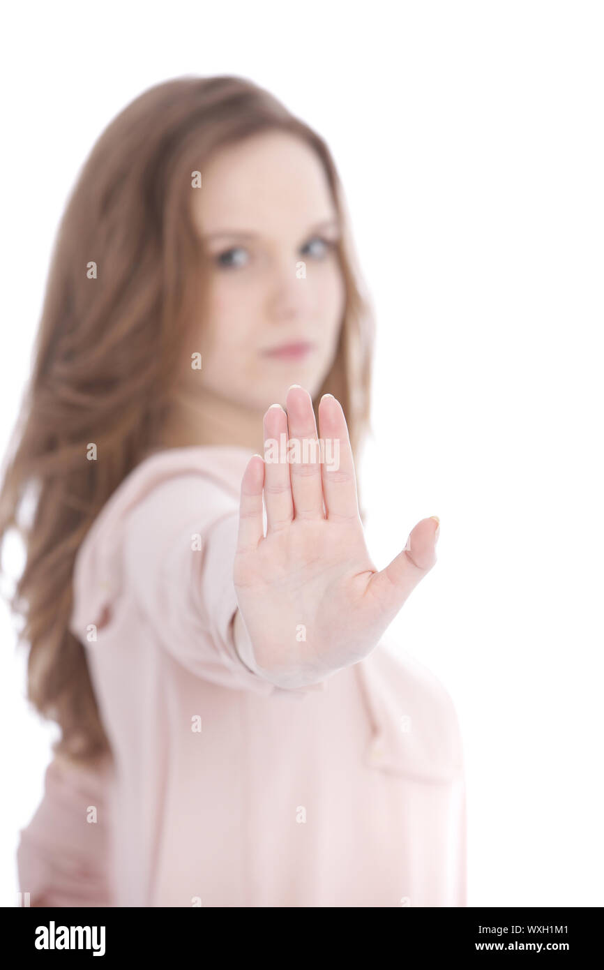 Young woman with a stern expression giving a Stop gesture with her hand ...