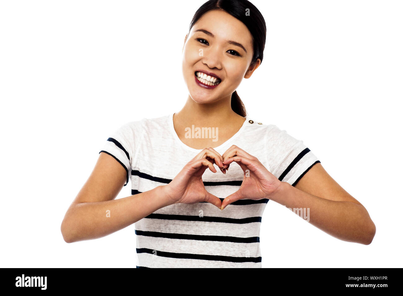 Pretty girl making heart symbol with hands Stock Photo - Alamy