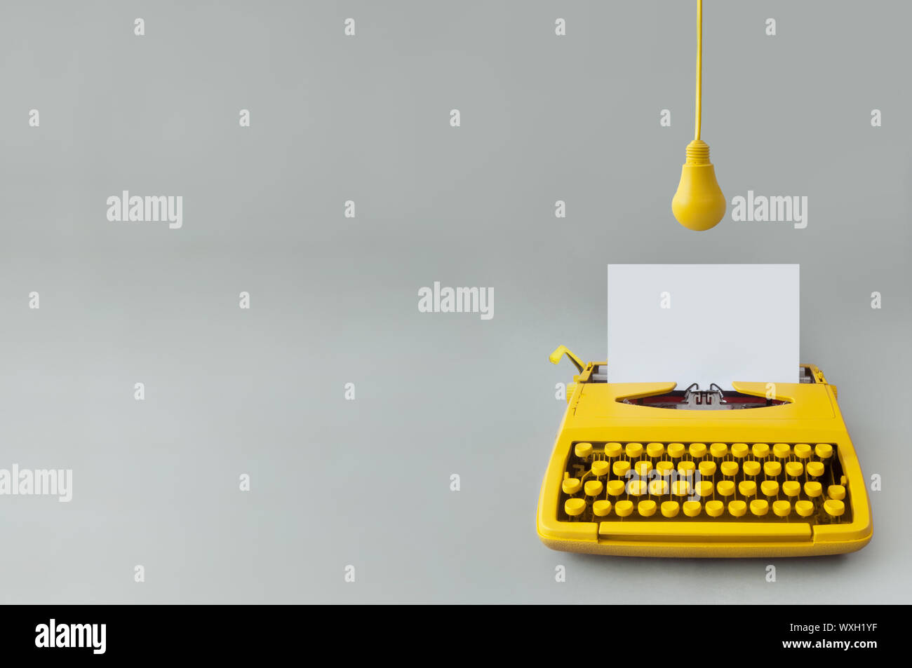 Retro typewriter with yellow hanging light bulb, inspiration, new ideas ...