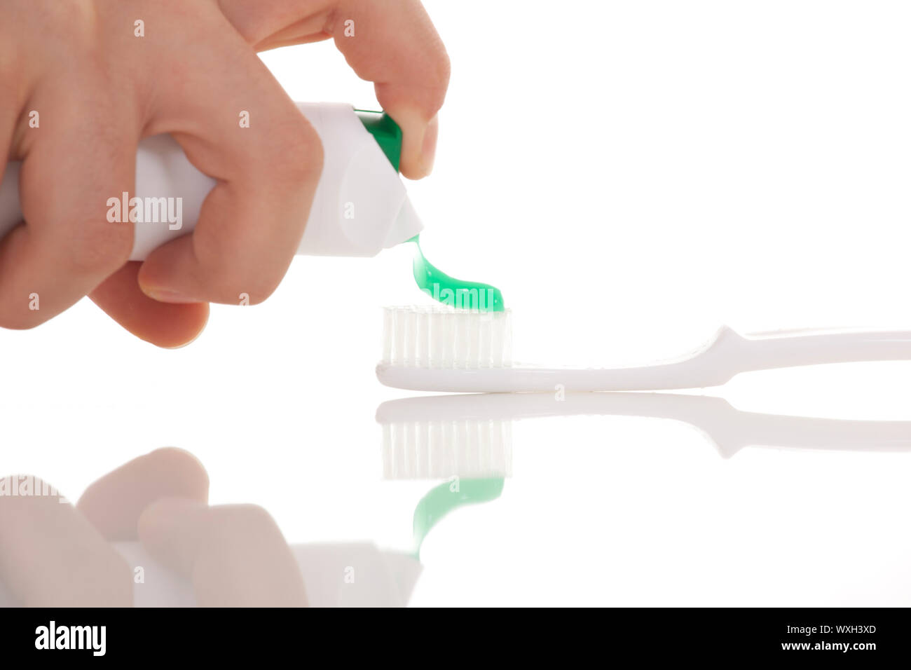 Squeezing toothpaste onto toothbrush Stock Photo - Alamy