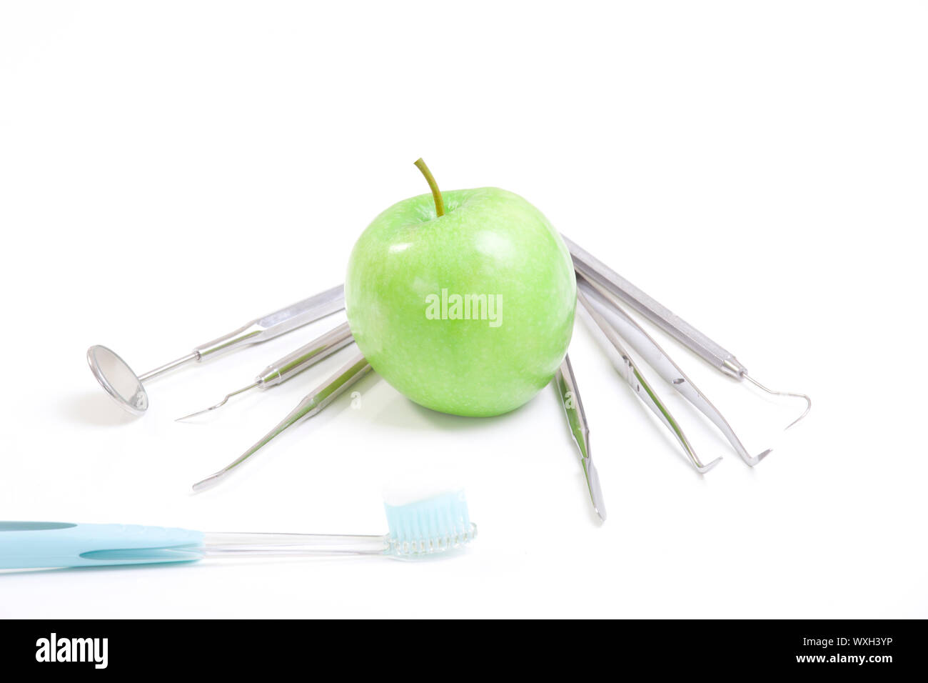 Green apple and dental tools isolated on white Stock Photo - Alamy