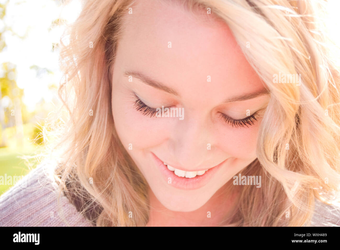 Beautiful blond girl smiling in the sunlight Stock Photo - Alamy