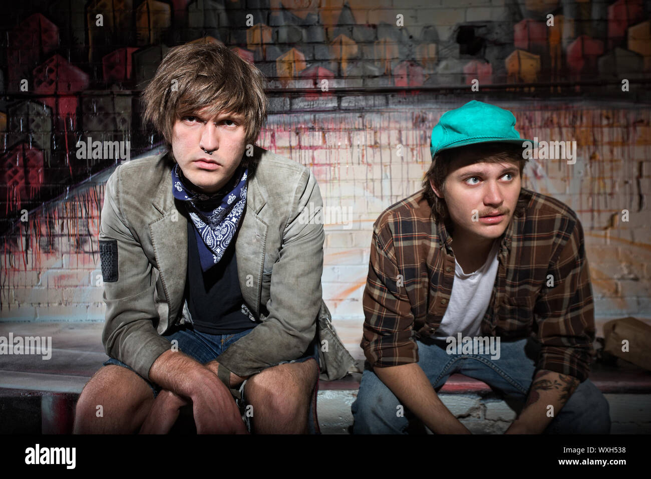 Pair of European homeless youth sitting on bench Stock Photo - Alamy