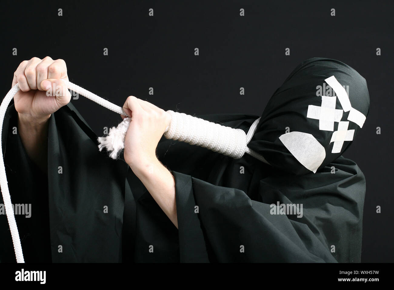 Black mime with rope on neck on black background Stock Photo - Alamy