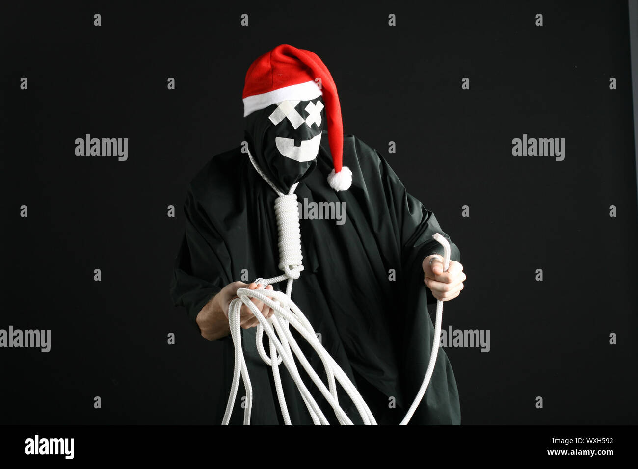 Black mime with rope on neck on black background Stock Photo - Alamy