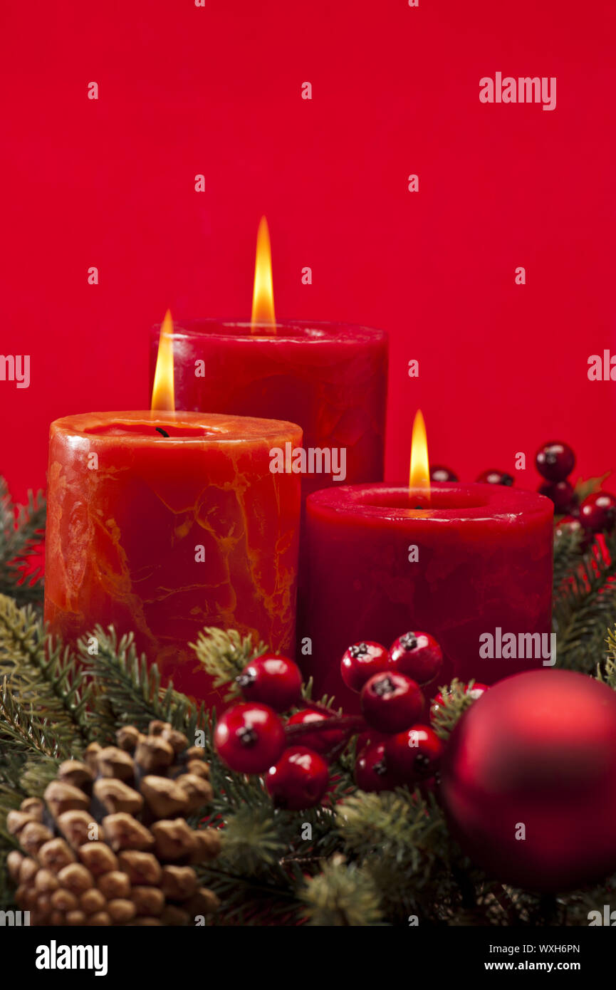 Red advent flower arangement with burning candles Stock Photo - Alamy
