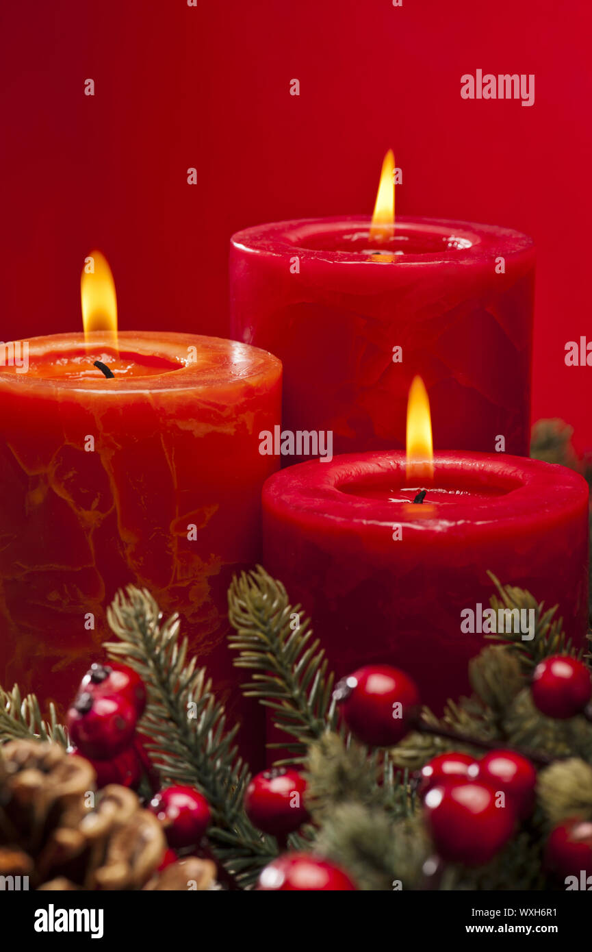 Red advent flower arangement with burning candles Stock Photo - Alamy
