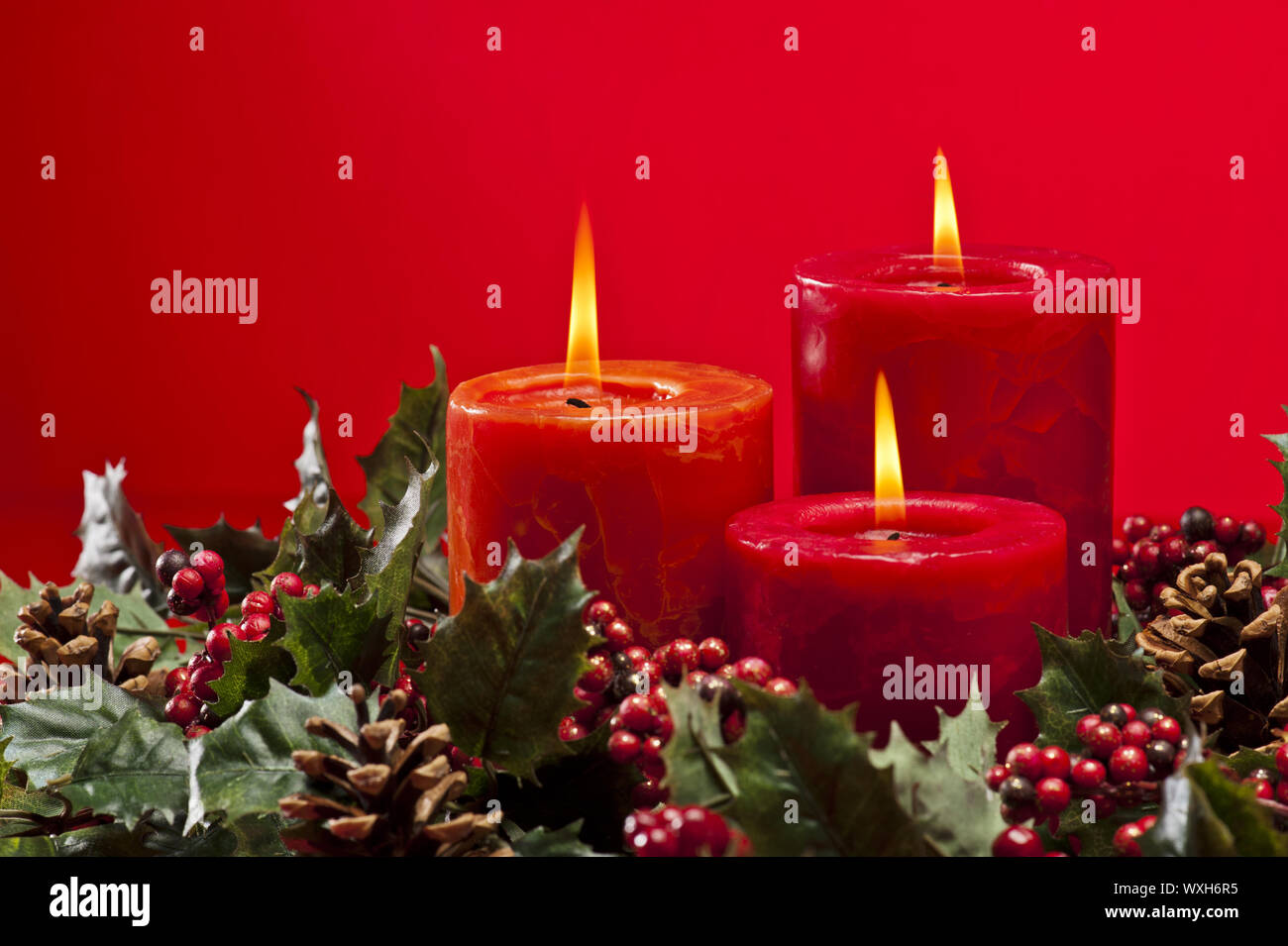 Red advent flower arangement with burning candles Stock Photo - Alamy