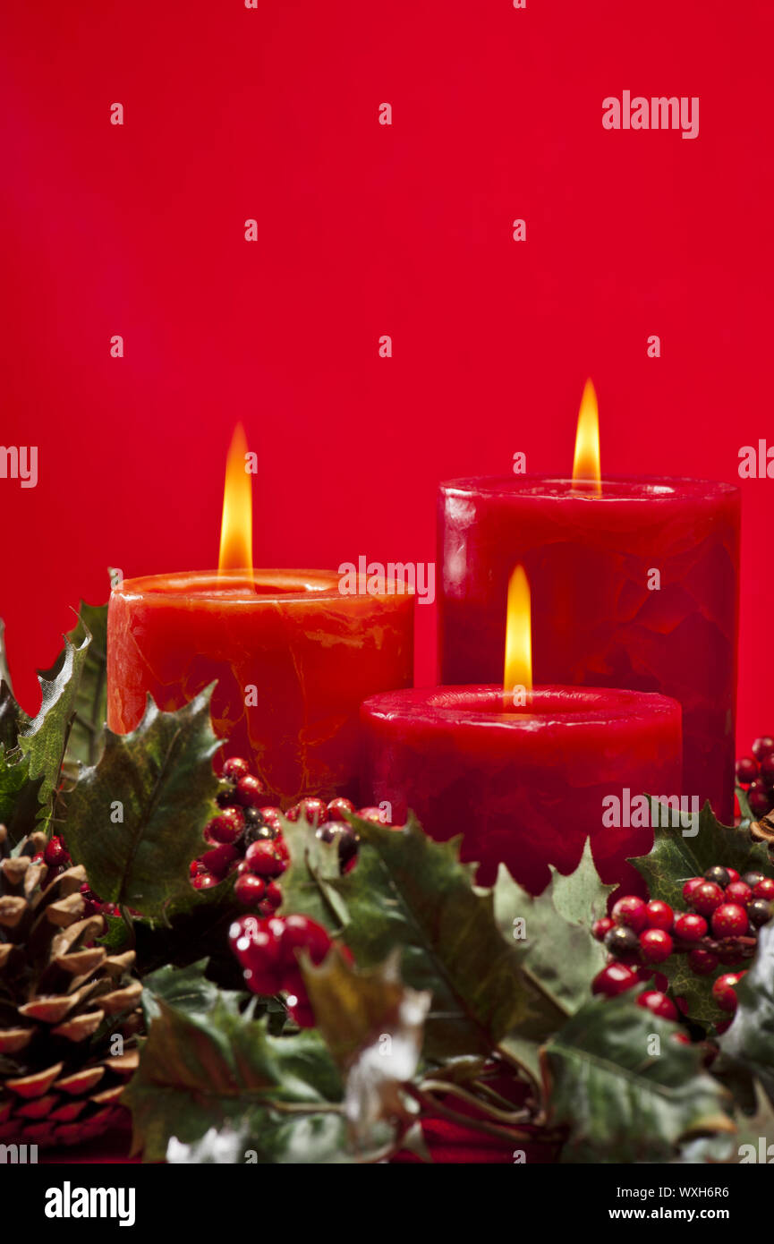 Red advent flower arangement with burning candles Stock Photo - Alamy