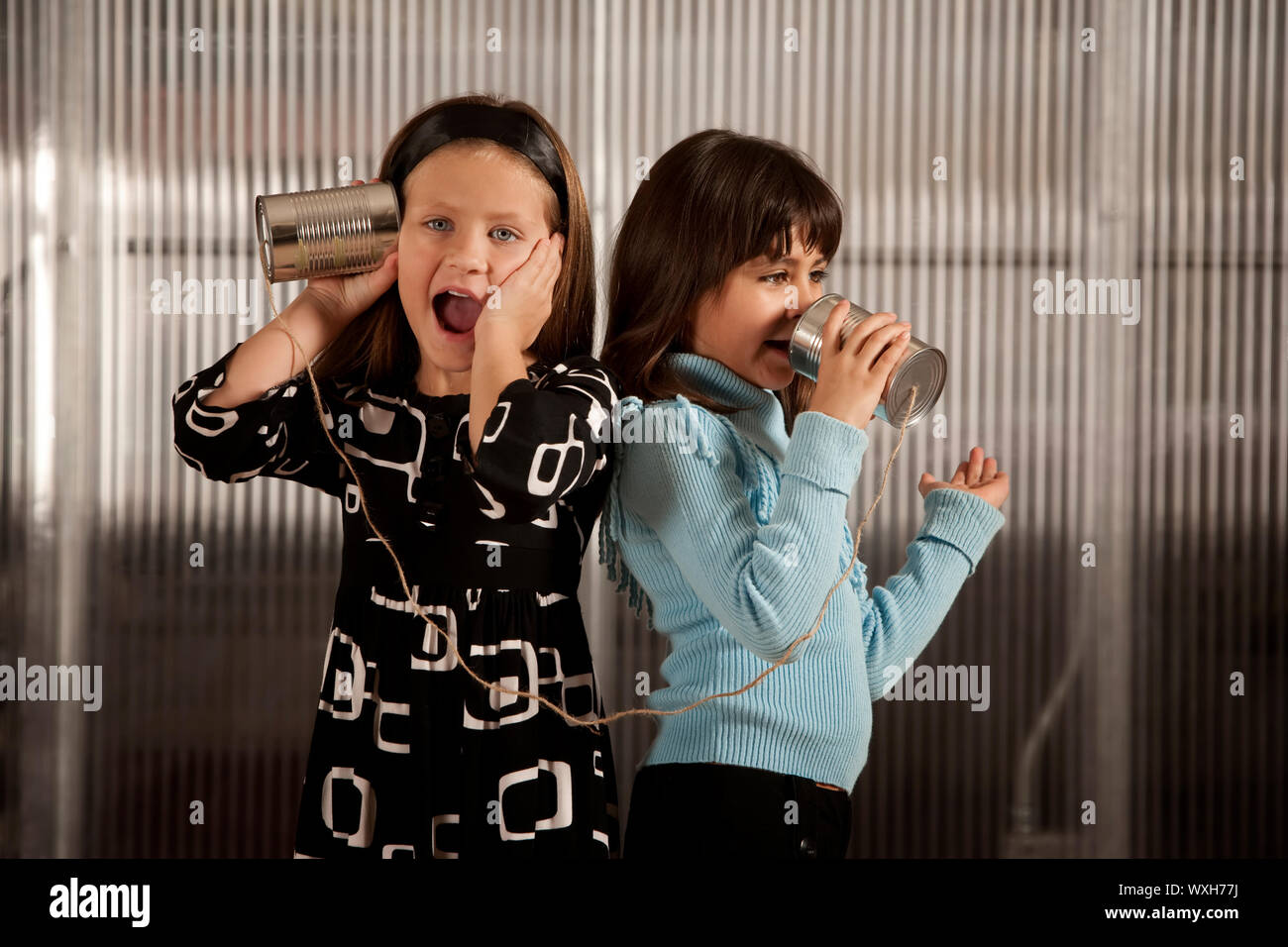 Little gril getting shocking message from friend on tin can phone Stock ...