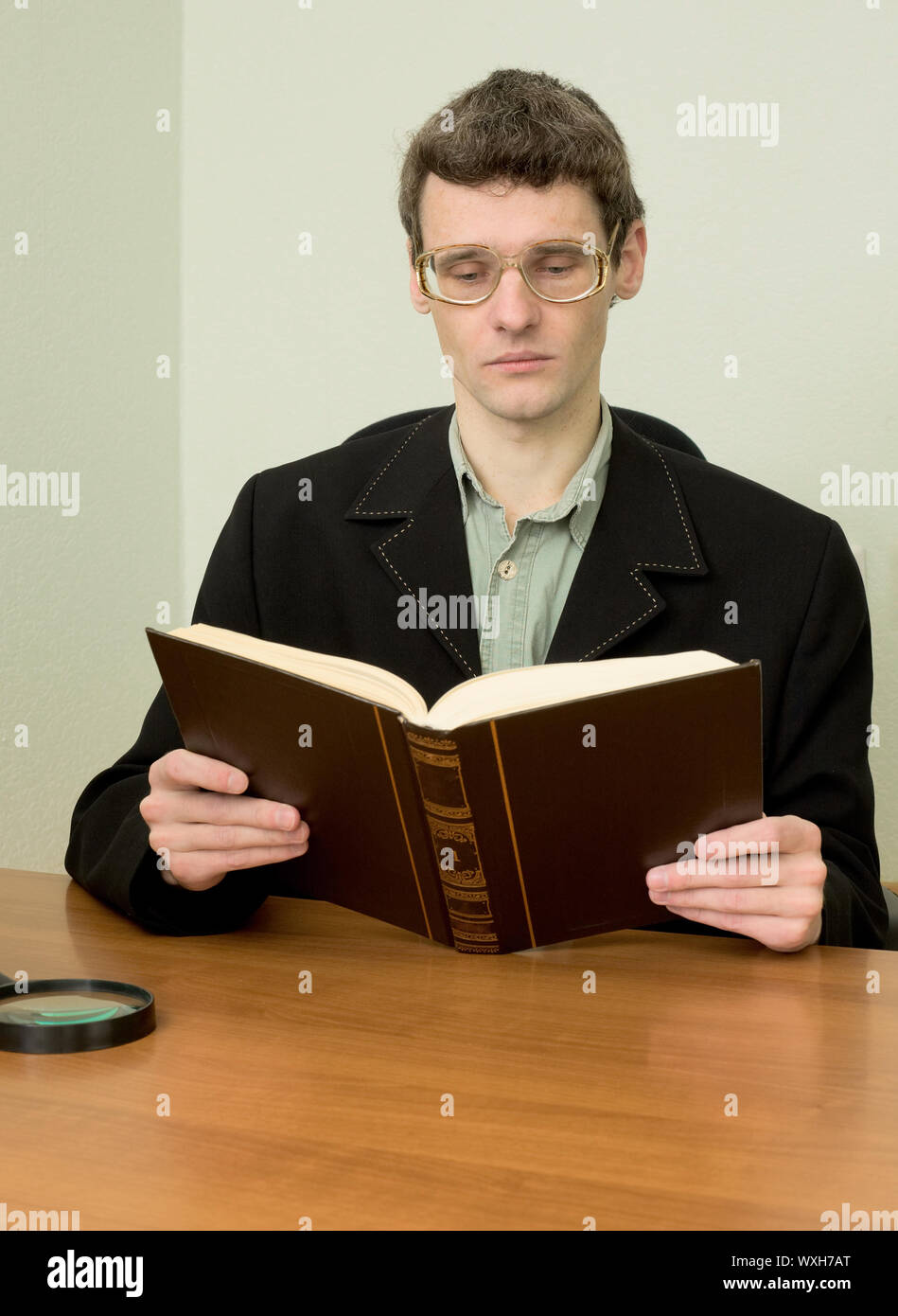 The guy in eyeglasses reads the book Stock Photo - Alamy